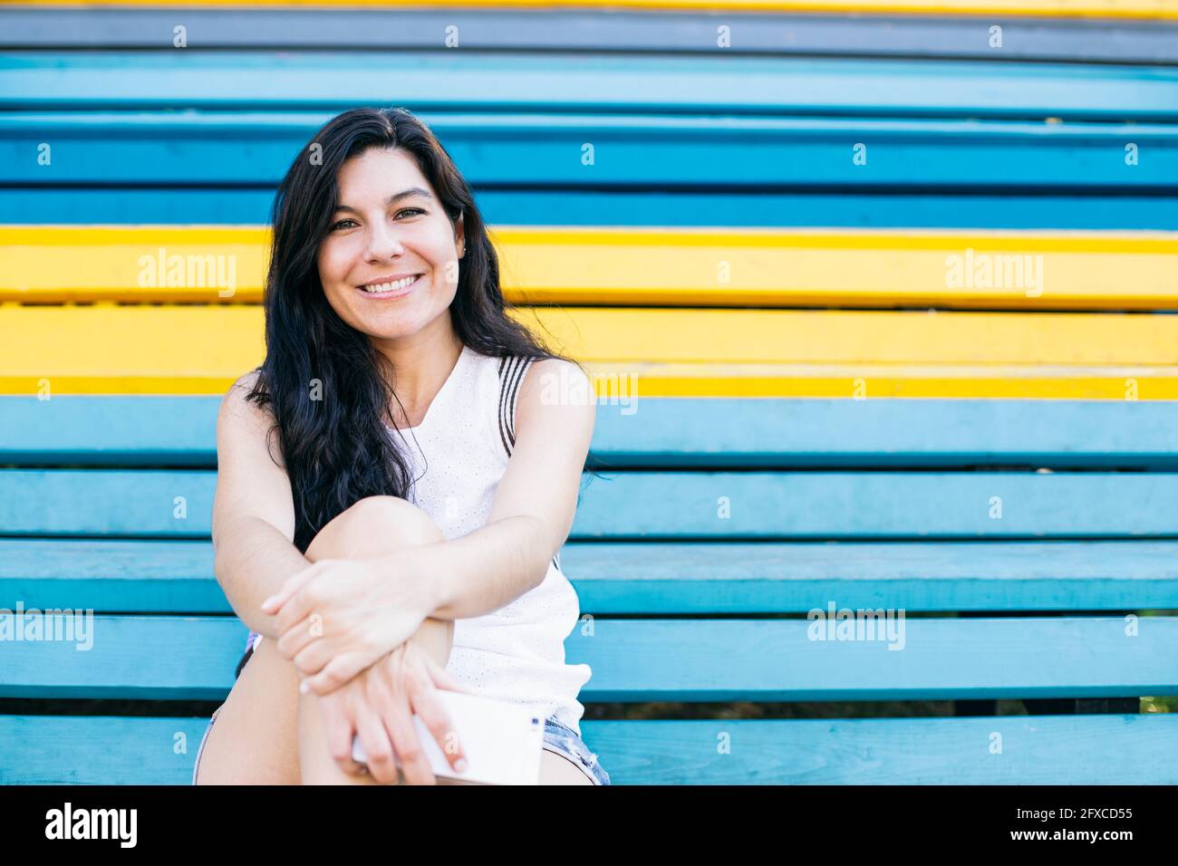Beautiful woman sitting on multi colored steps Stock Photo - Alamy
