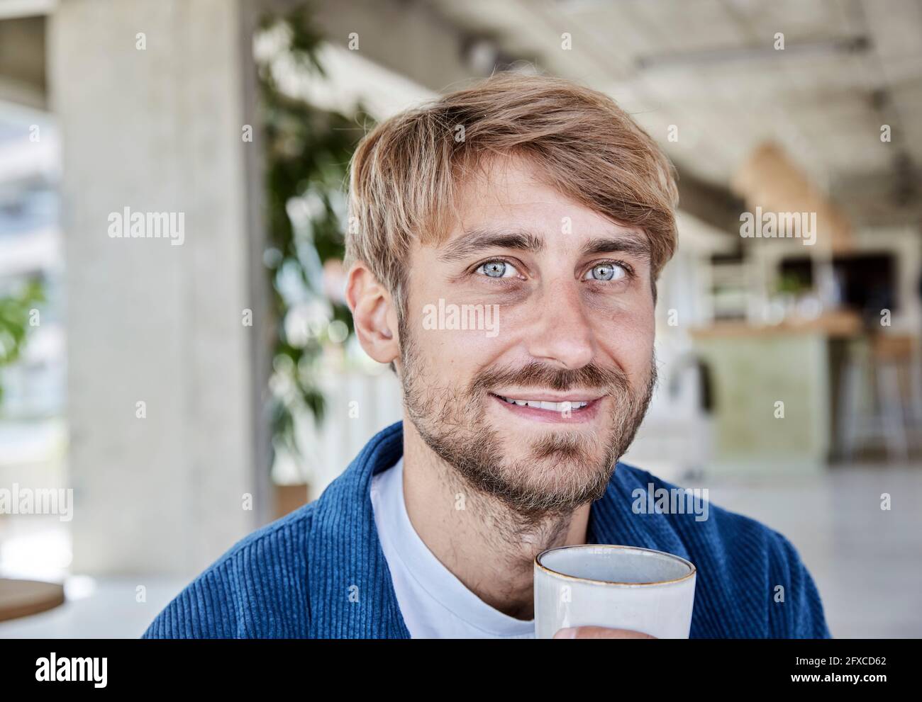Gray eyed man having coffee at loft Stock Photo - Alamy