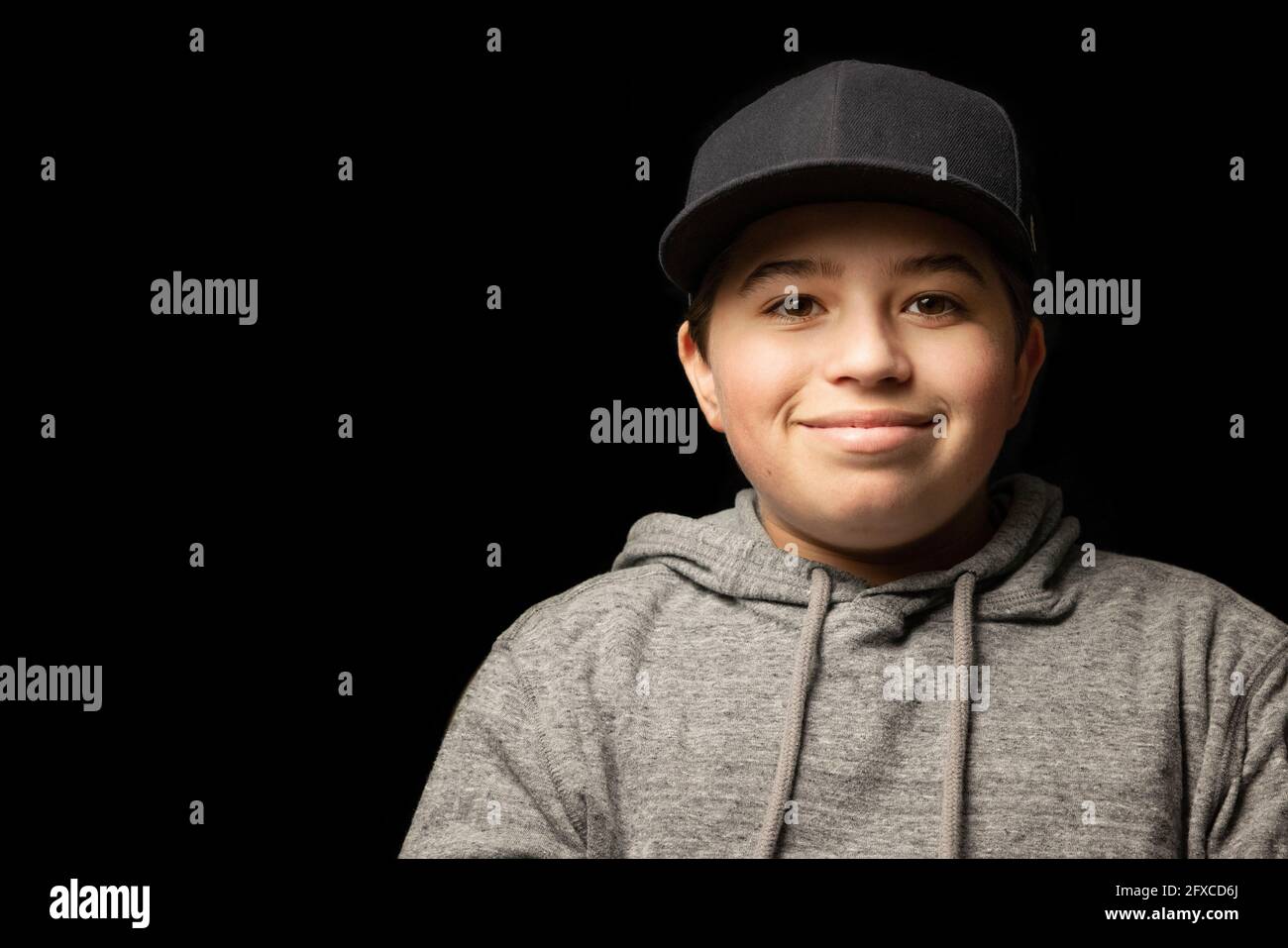 Boy wearing cap in front of black background Stock Photo - Alamy