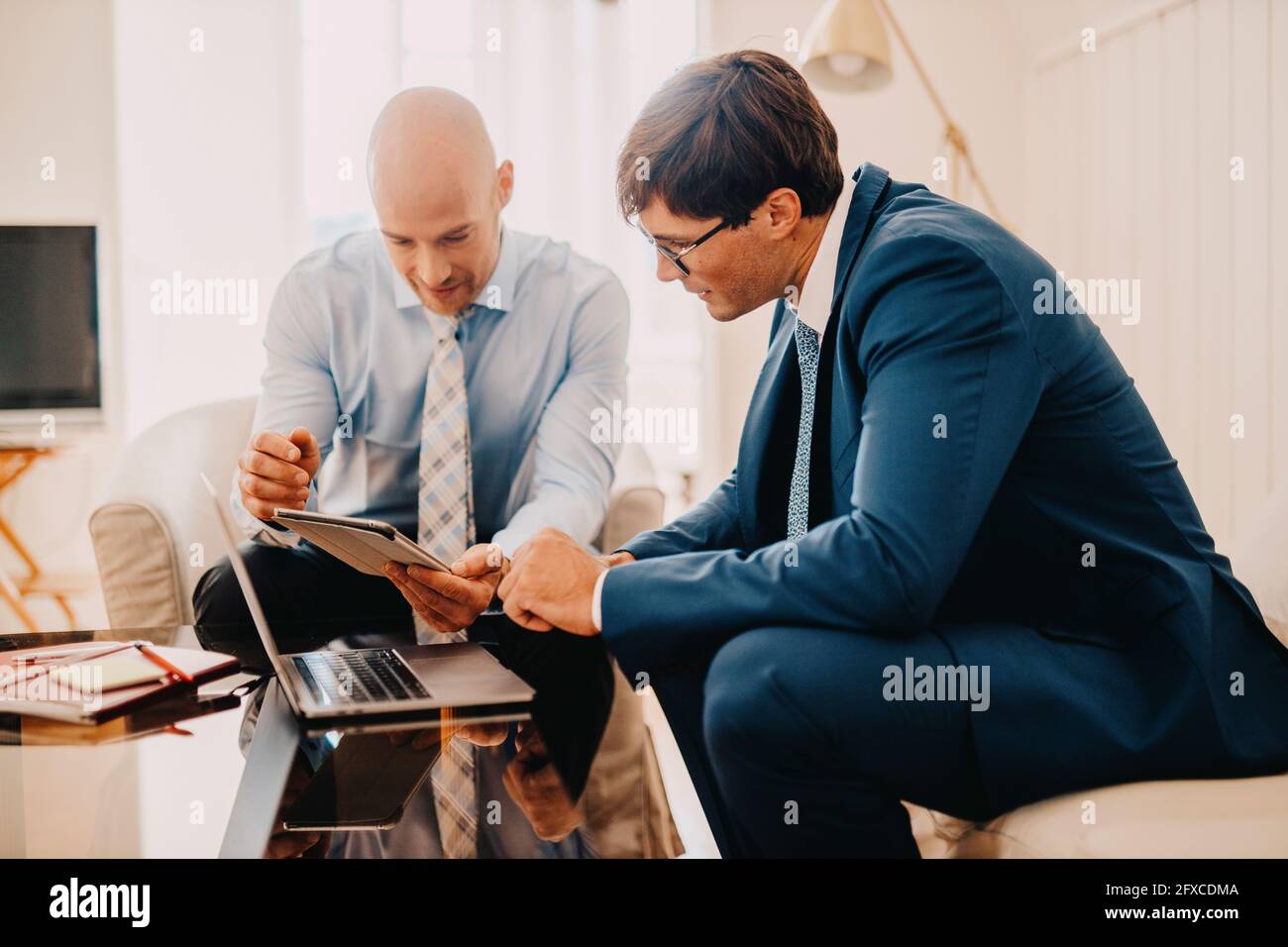 Mid adult male event planner discussing with groom Stock Photo - Alamy
