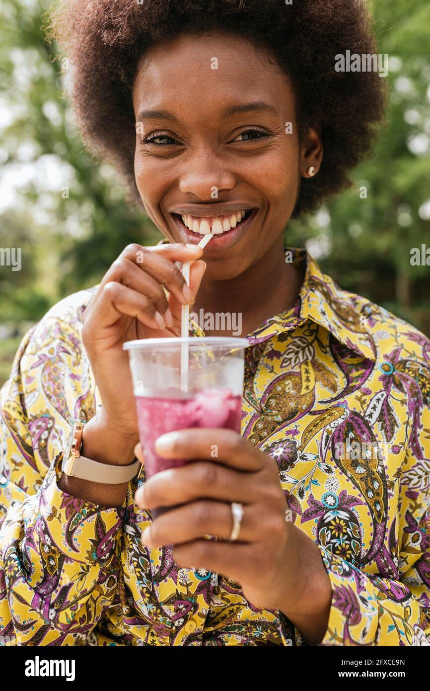 Woman smiling while having smoothie Stock Photo - Alamy