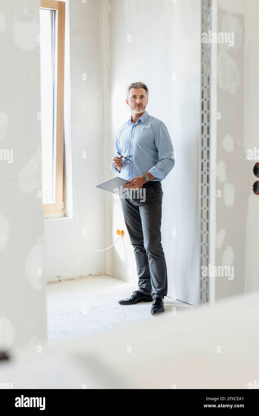 Man standing by wall at construction site Stock Photo - Alamy