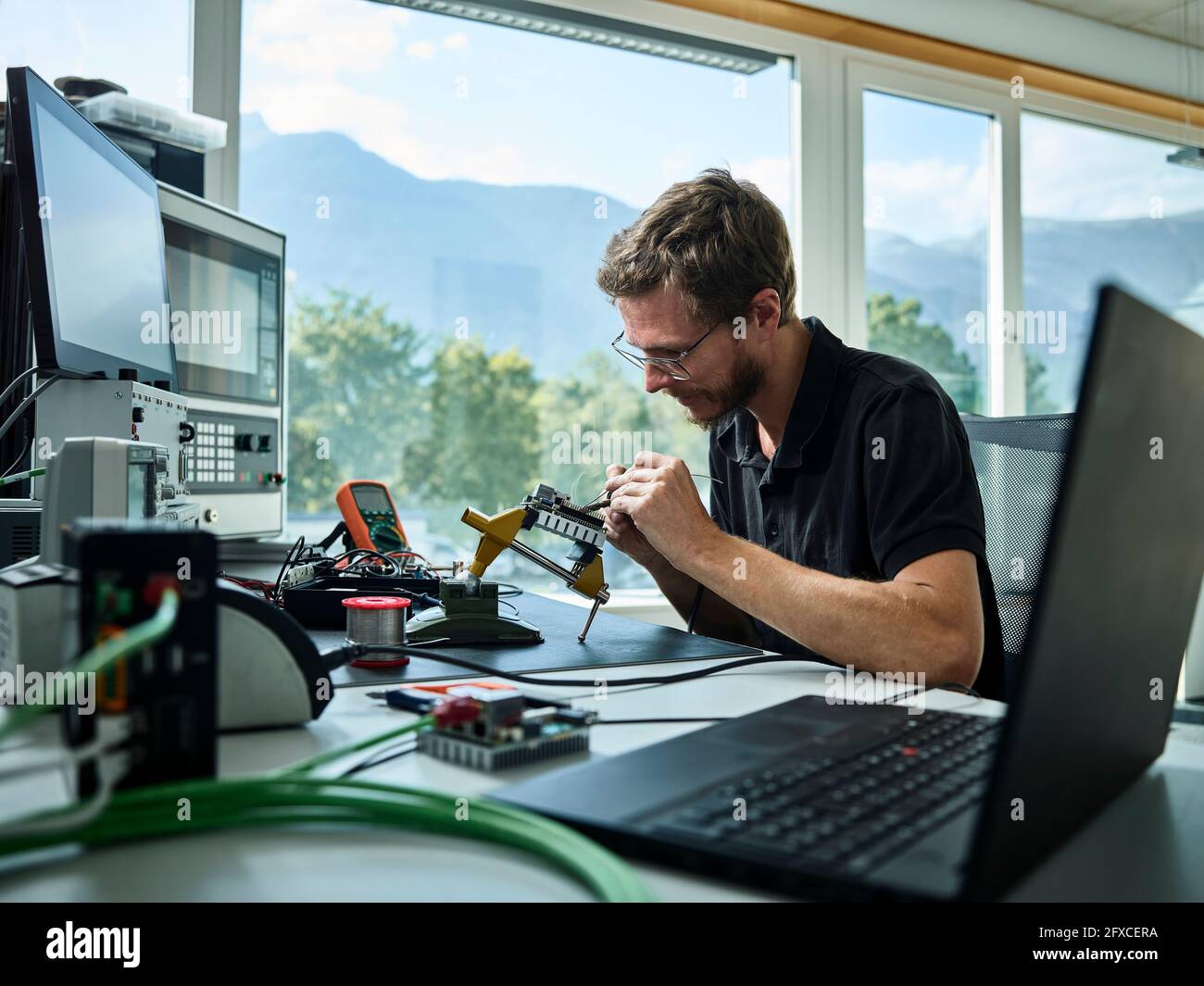 Male engineer soldering electrical component at factory Stock Photo - Alamy