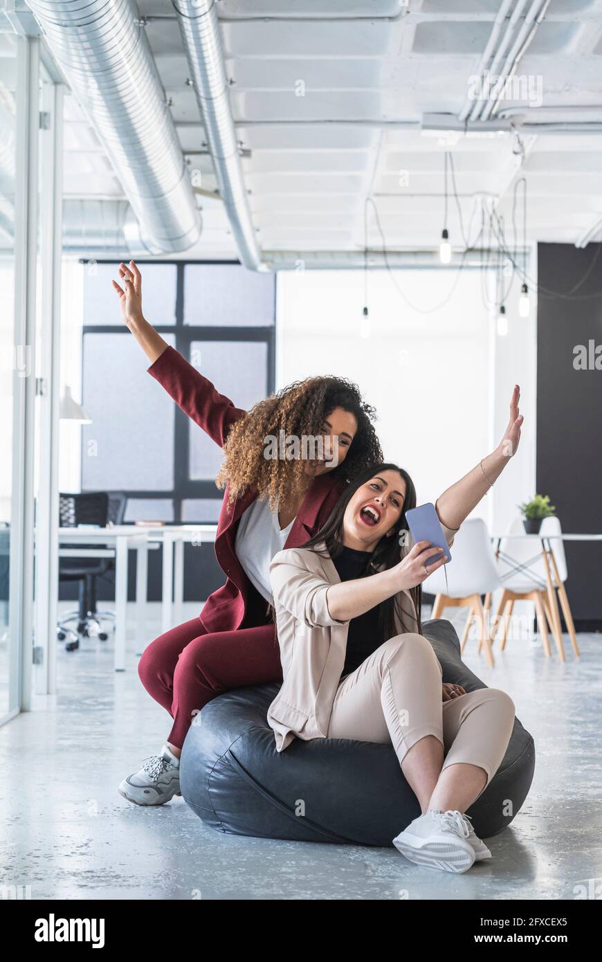 Female Entrepreneurs With Arms Raised Having Fun While Taking Selfie