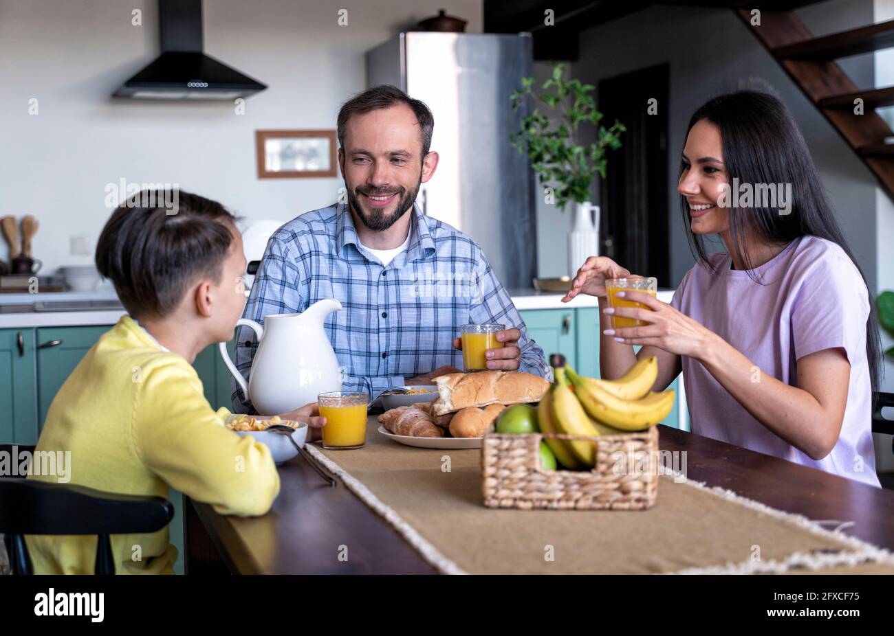 Family having breakfast on dining table at home Stock Photo - Alamy