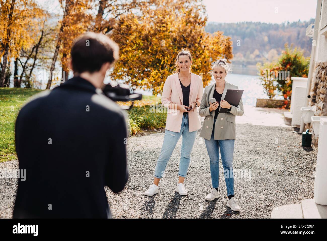 Male photographer photographing two women Stock Photo - Alamy