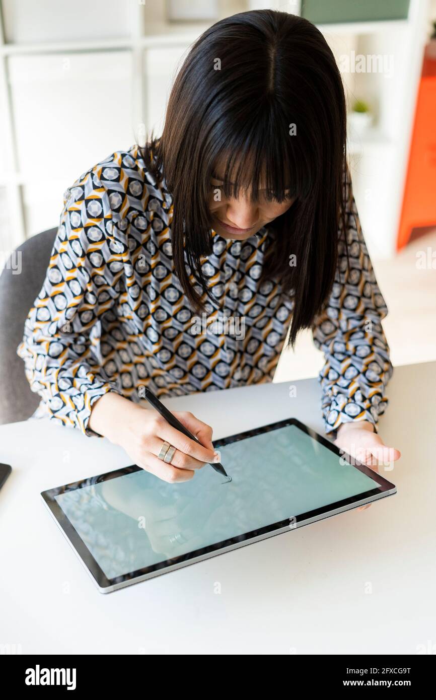 Female design professional using graphic tablet at desk Stock Photo - Alamy