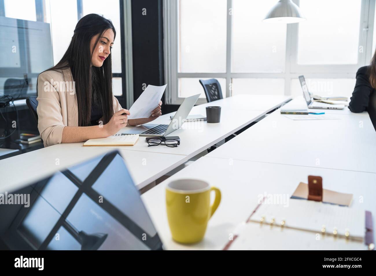 Female professional reading document in coworking office Stock Photo ...