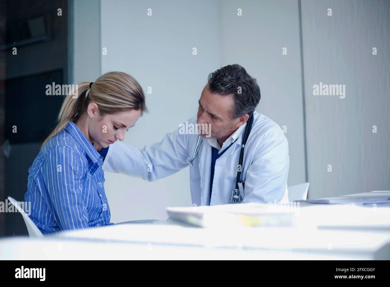 Male doctor consoling female patient in hospital Stock Photo - Alamy