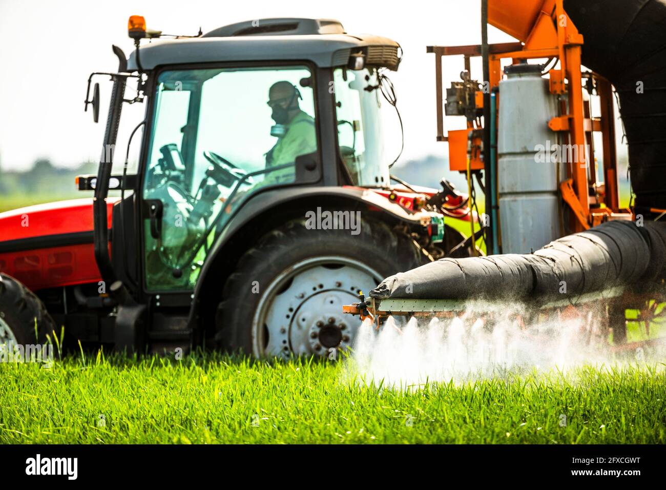 Male farmer in tractor spraying fungicide on crop Stock Photo - Alamy