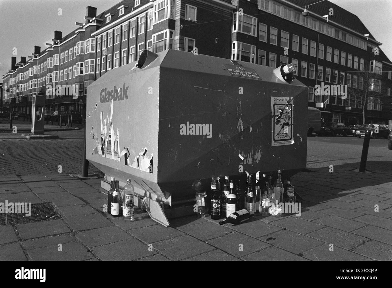 Overfilled glass container with bottles next to it, November 24, 1981 ...
