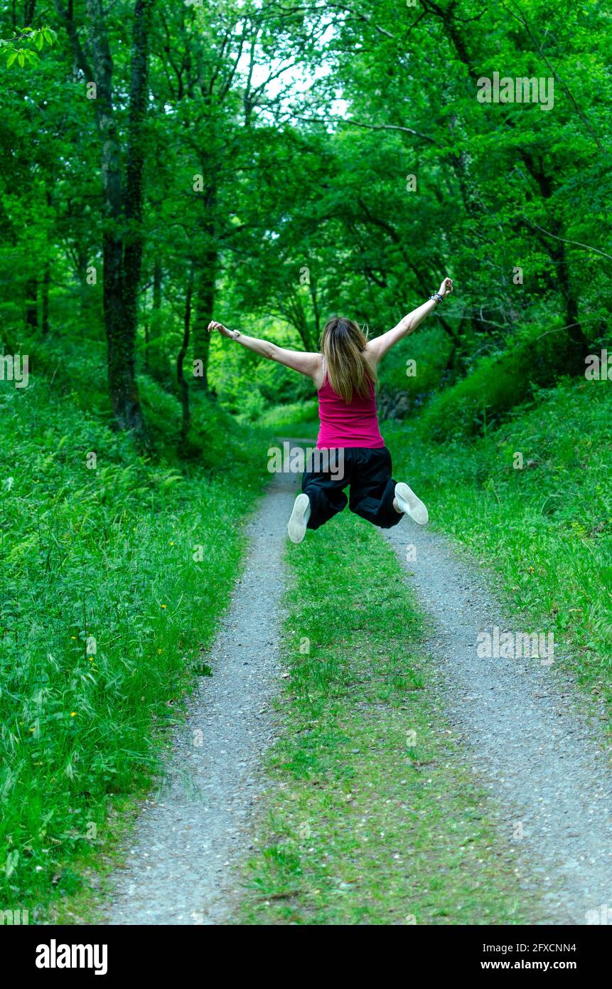 woman jumping in the forest relaxing Stock Photo - Alamy