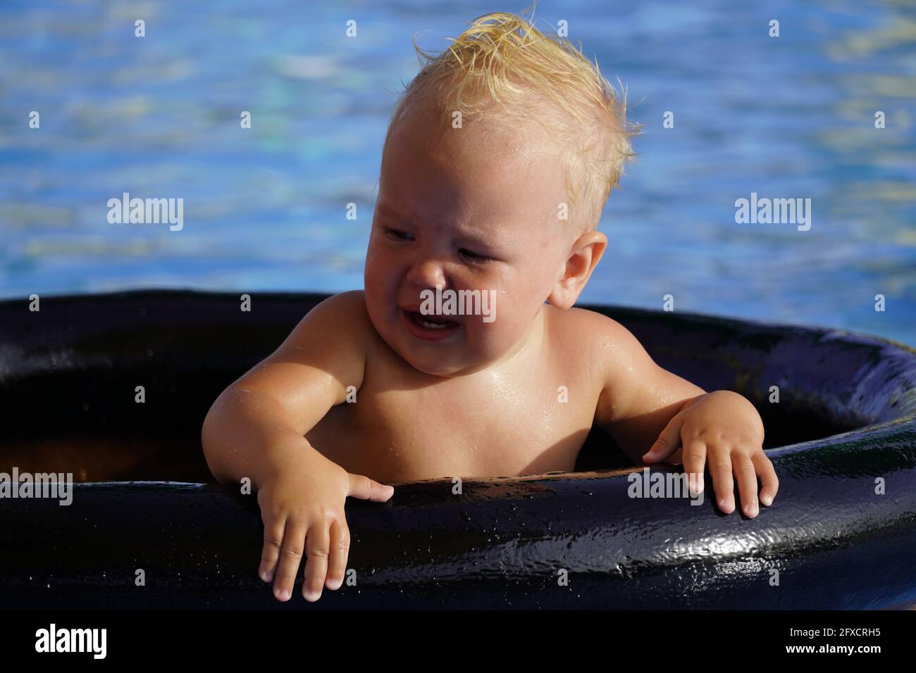 Little boy with blond hair crying in children's pool Stock Photo - Alamy