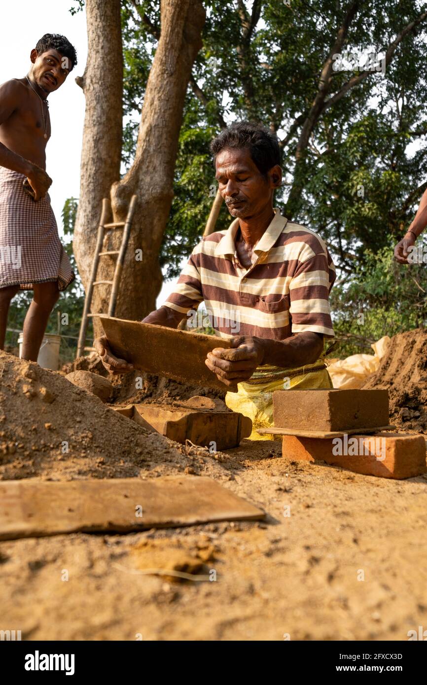 Men making clay bricks by hand in a rural village in Nayagarh, Odisha ...