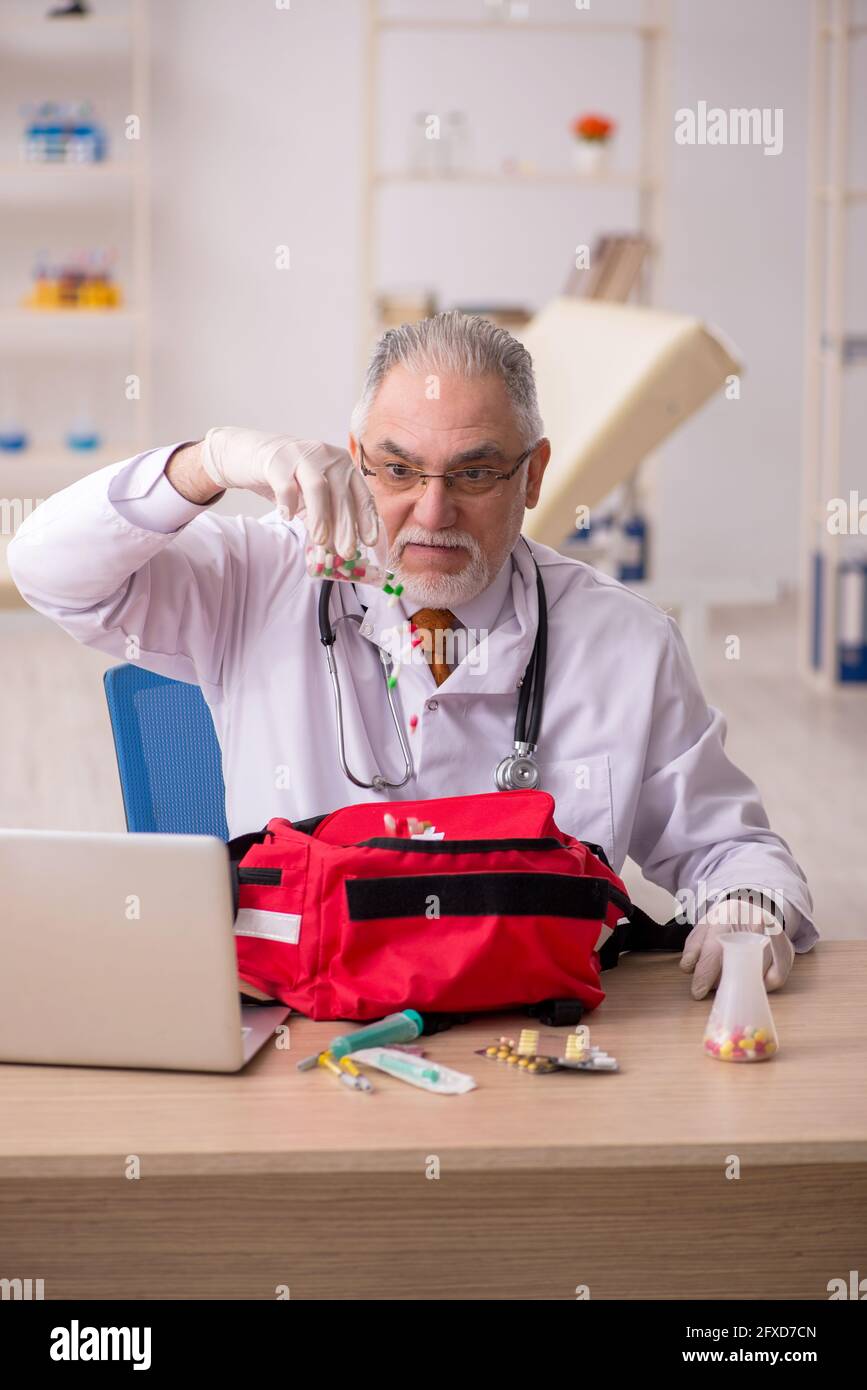 Old doctor in first aid concept Stock Photo - Alamy