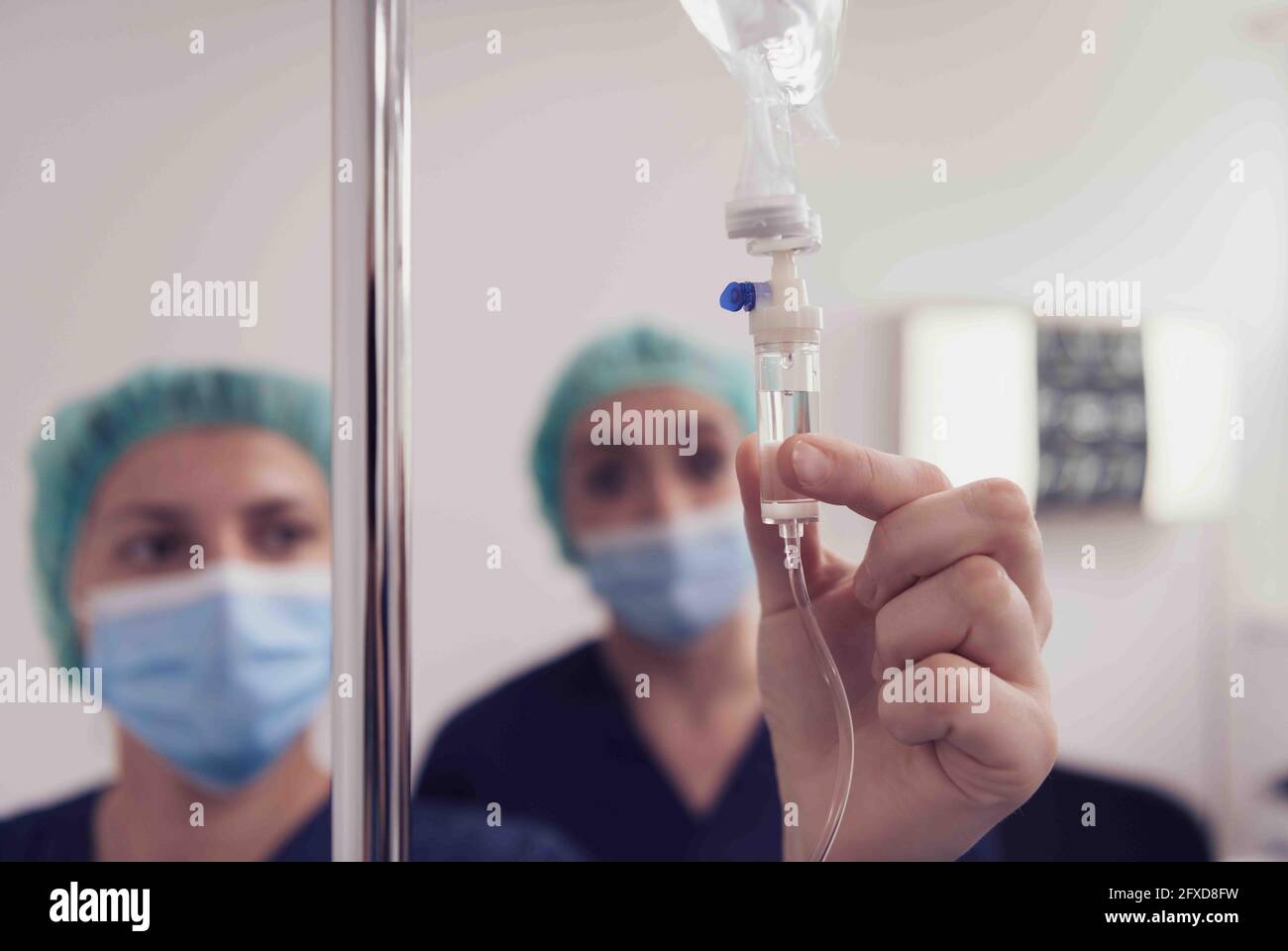 General practitioner holding intravenous drip infusion. Doctor handling ...