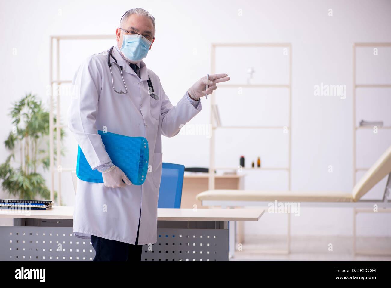 Old doctor working in the clinic Stock Photo - Alamy