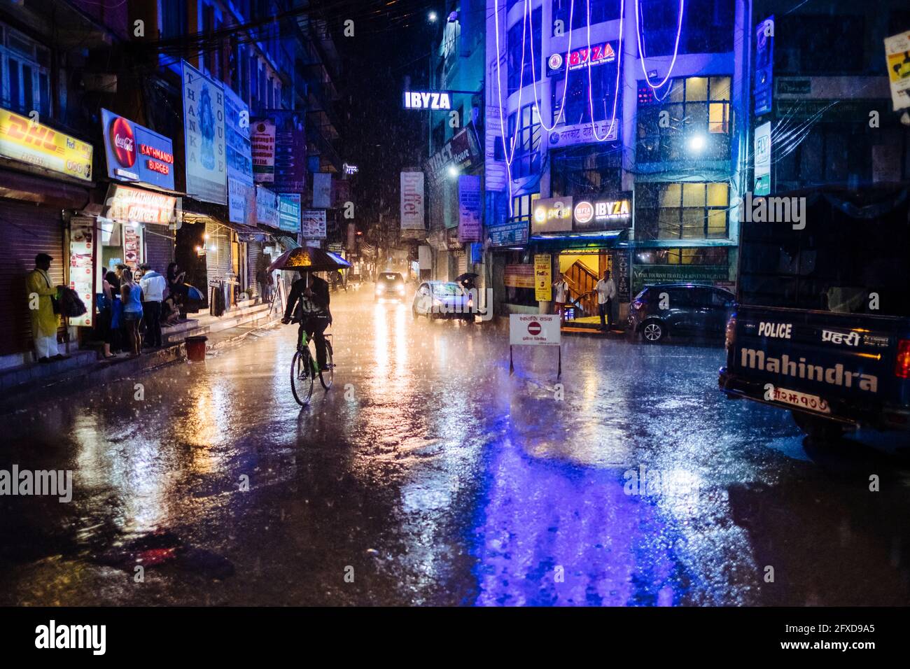 Nepali man cycling in Kathmandu main streets of Thamel during heavy ...