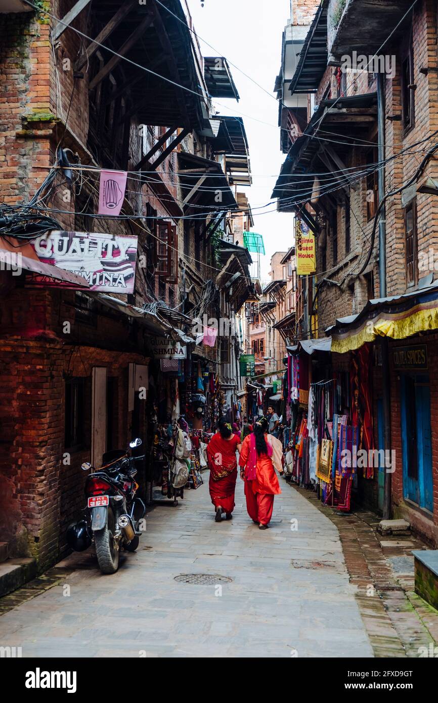 A couple Nepali woman walking through street market street in Bhaktapur ...