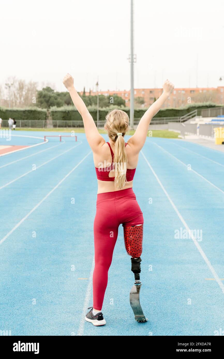 Back view of handicapped race winner running on track Stock Photo - Alamy