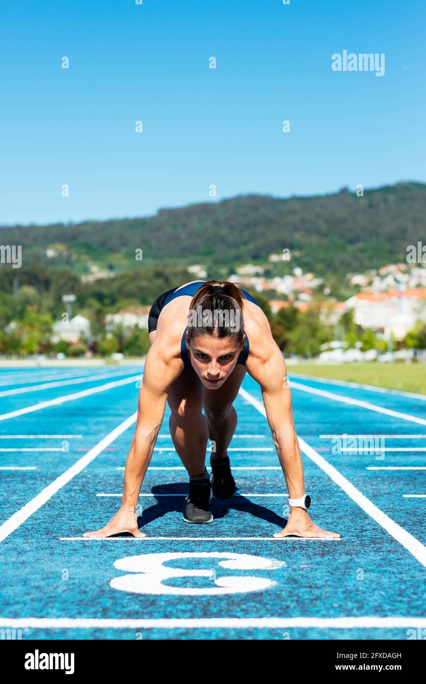 Woman athlete on running field in starting position Stock Photo - Alamy