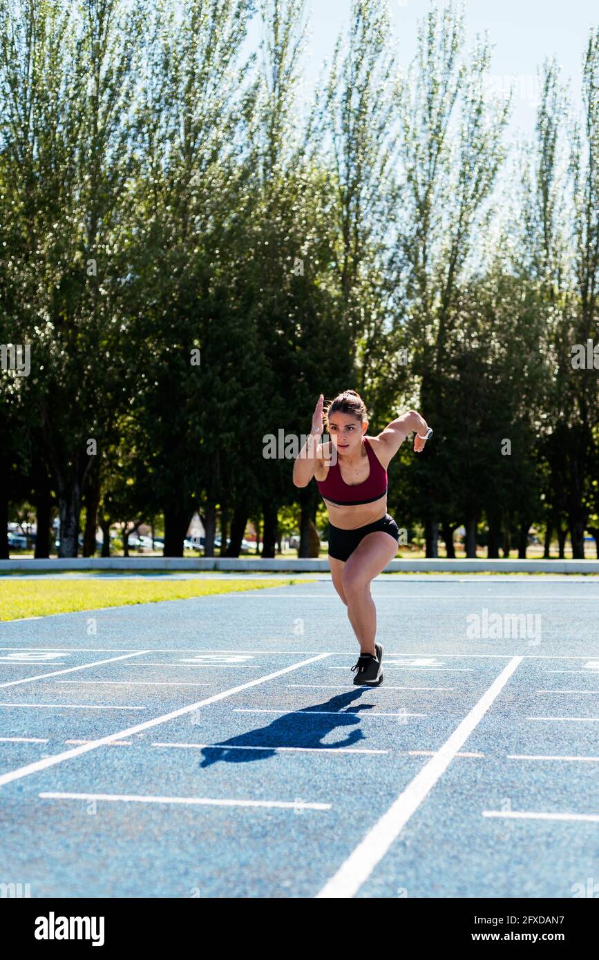 Athletic woman sprinting on track Stock Photo - Alamy