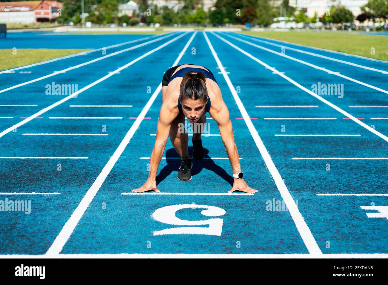 Woman athlete on running field in starting position Stock Photo - Alamy