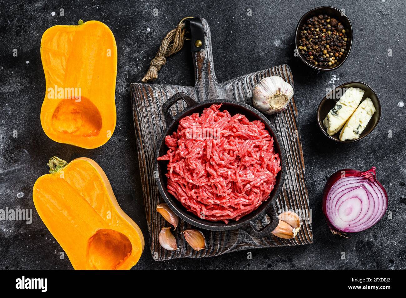 Raw mince meat, pumpkin with garlic and onion. Black background. Top ...
