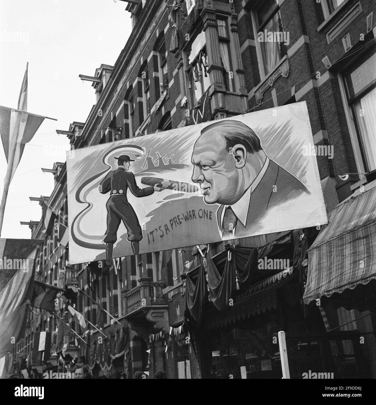 [Banner in the street. Image of Churchill receiving a cigar from a ...