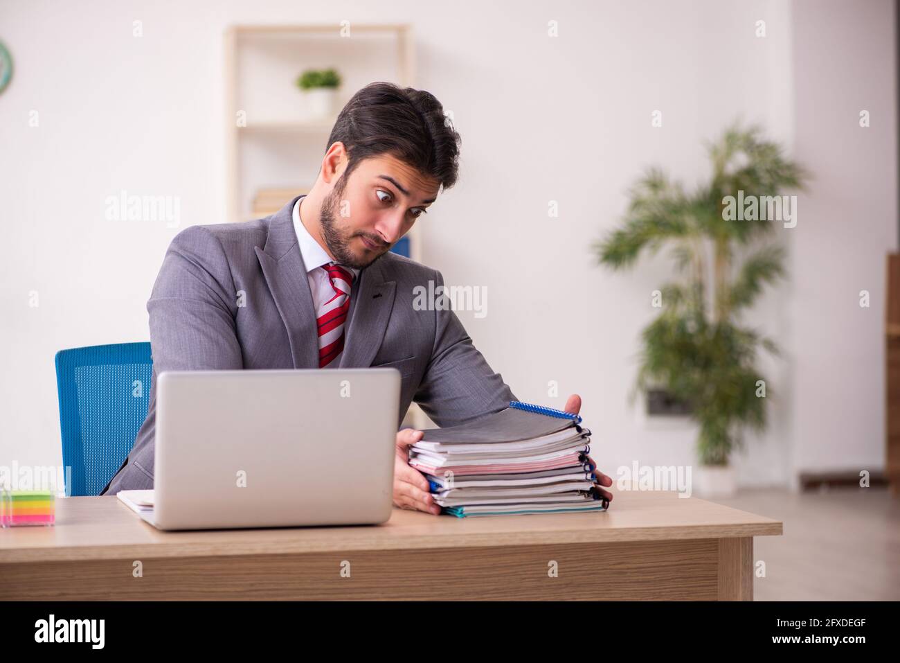 Young male employee working at workplace Stock Photo - Alamy