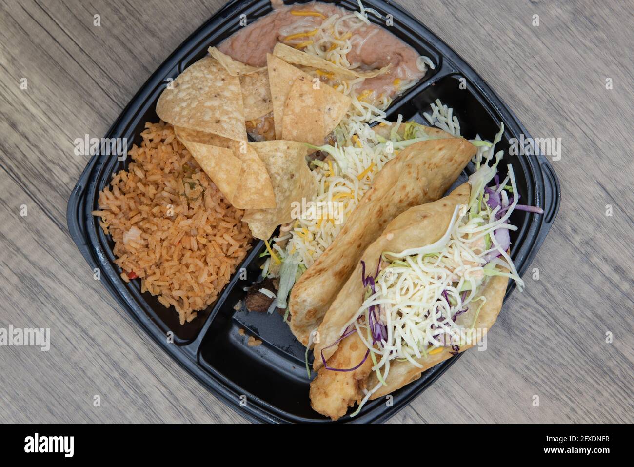 Overhead view of two kinds of tacos served with all the fillings, rice ...