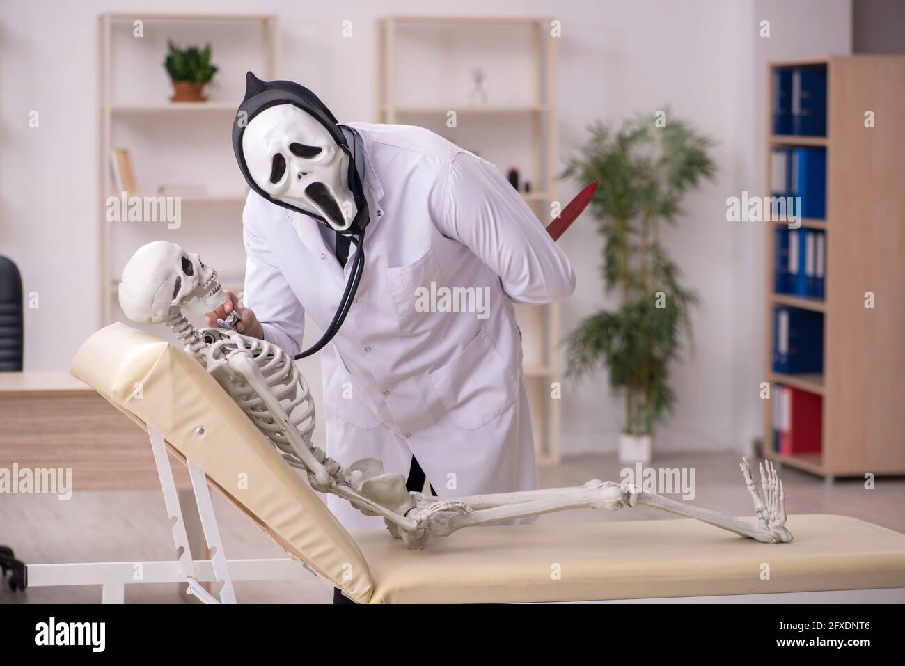 Devil doctor examining skeleton patient in the clinic Stock Photo - Alamy