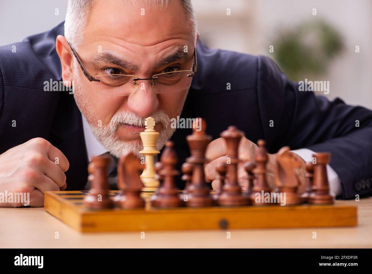Old businessman employee playing chess at workplace Stock Photo - Alamy