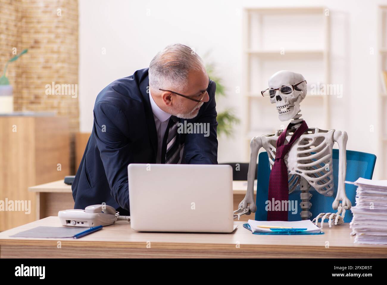 Dead employee working in the office in funny concept Stock Photo - Alamy