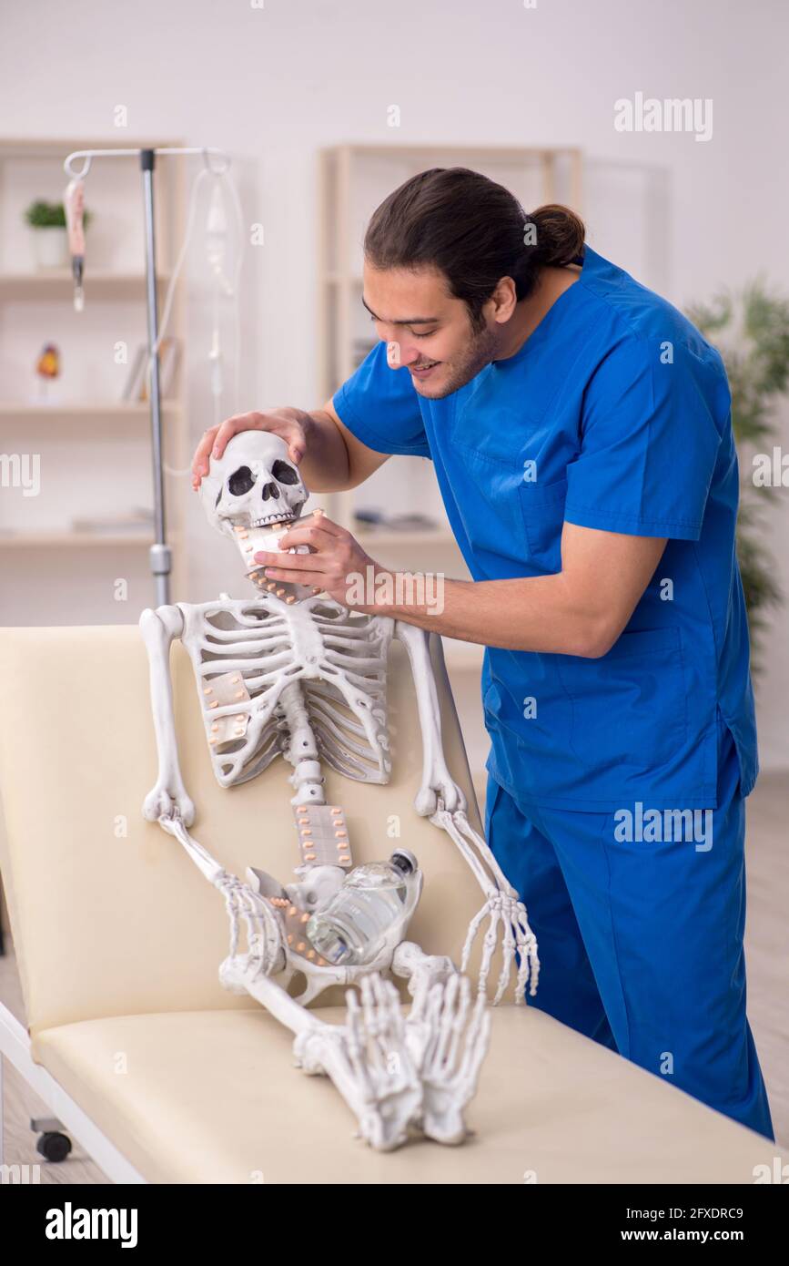 Young doctor suggesting pills to skeleton patient Stock Photo - Alamy