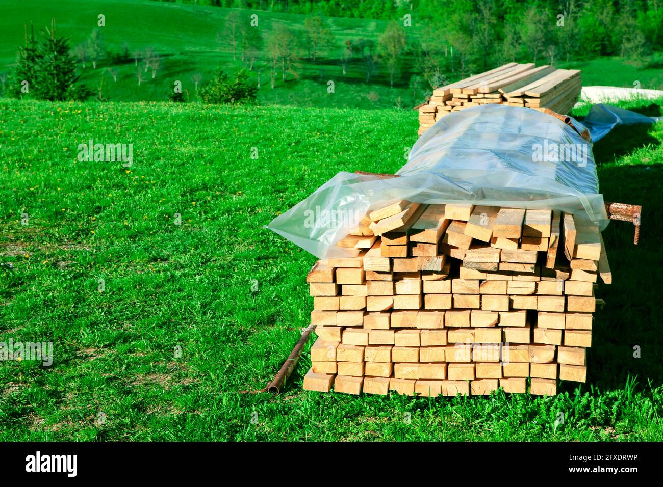 Stack of wood boards on the grass . Stacked wooden planks for rustic ...
