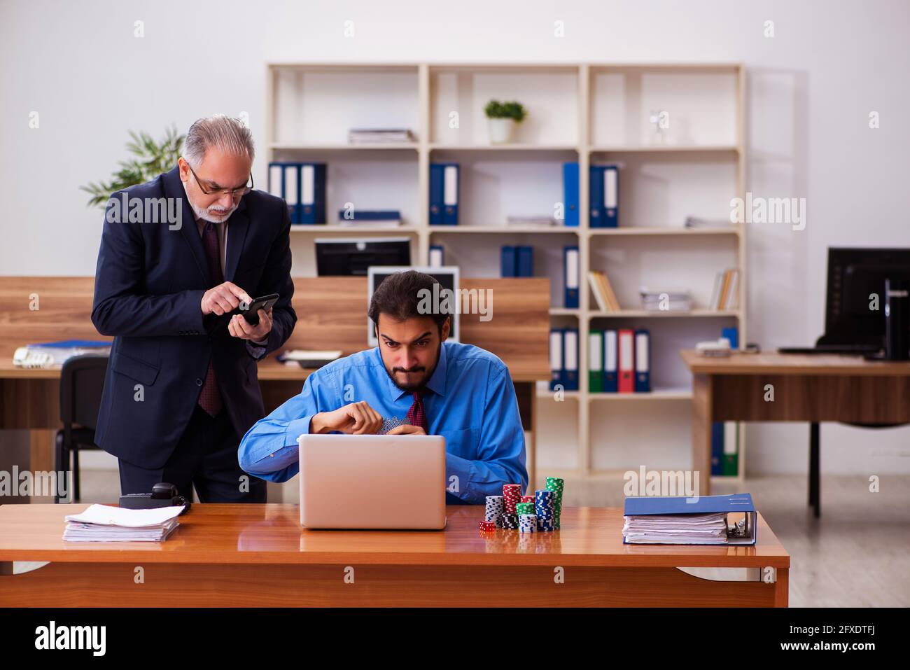 Two male employees in gambling concept in the office Stock Photo - Alamy