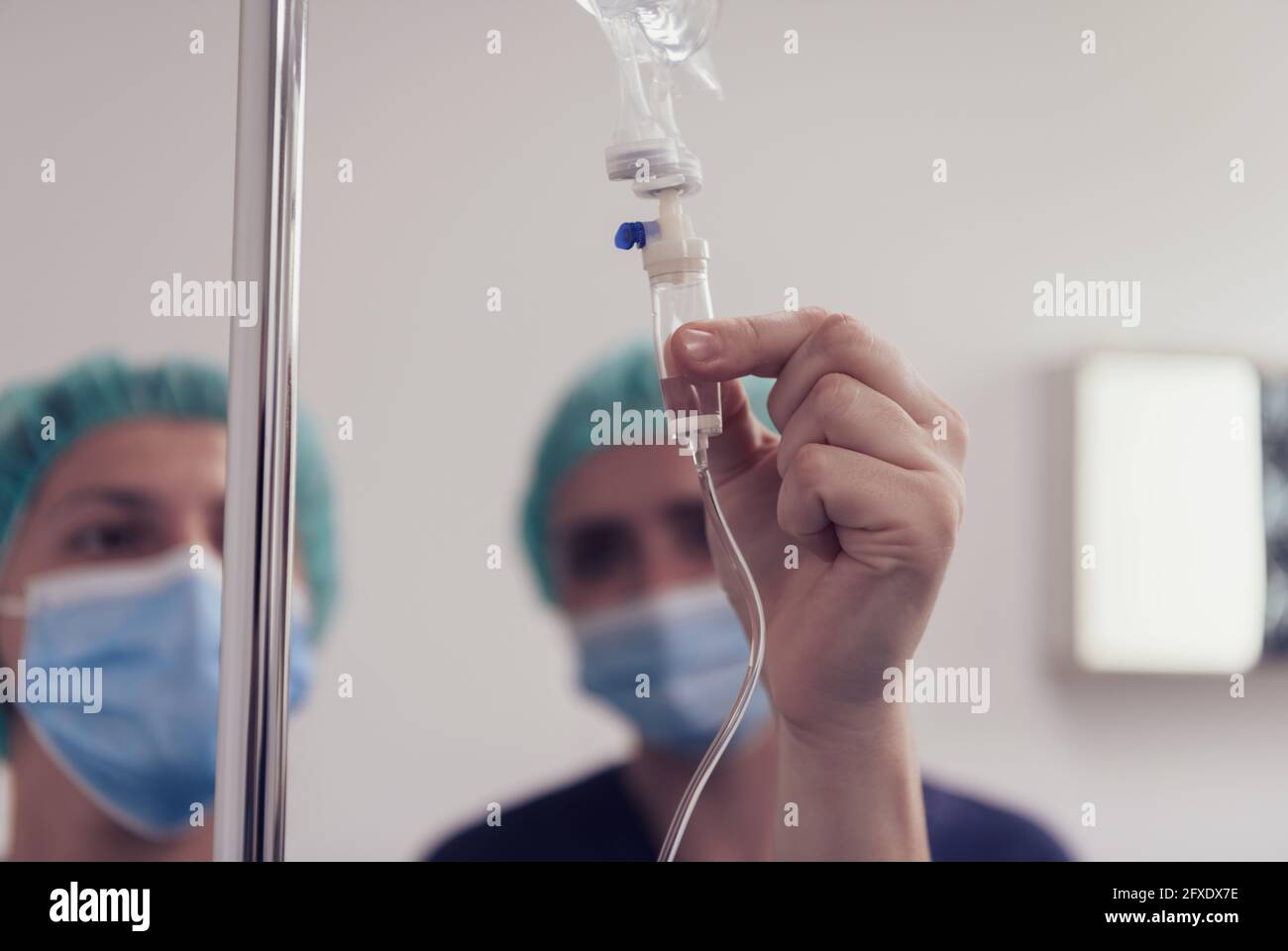 General practitioner holding intravenous drip infusion. Doctor handling ...