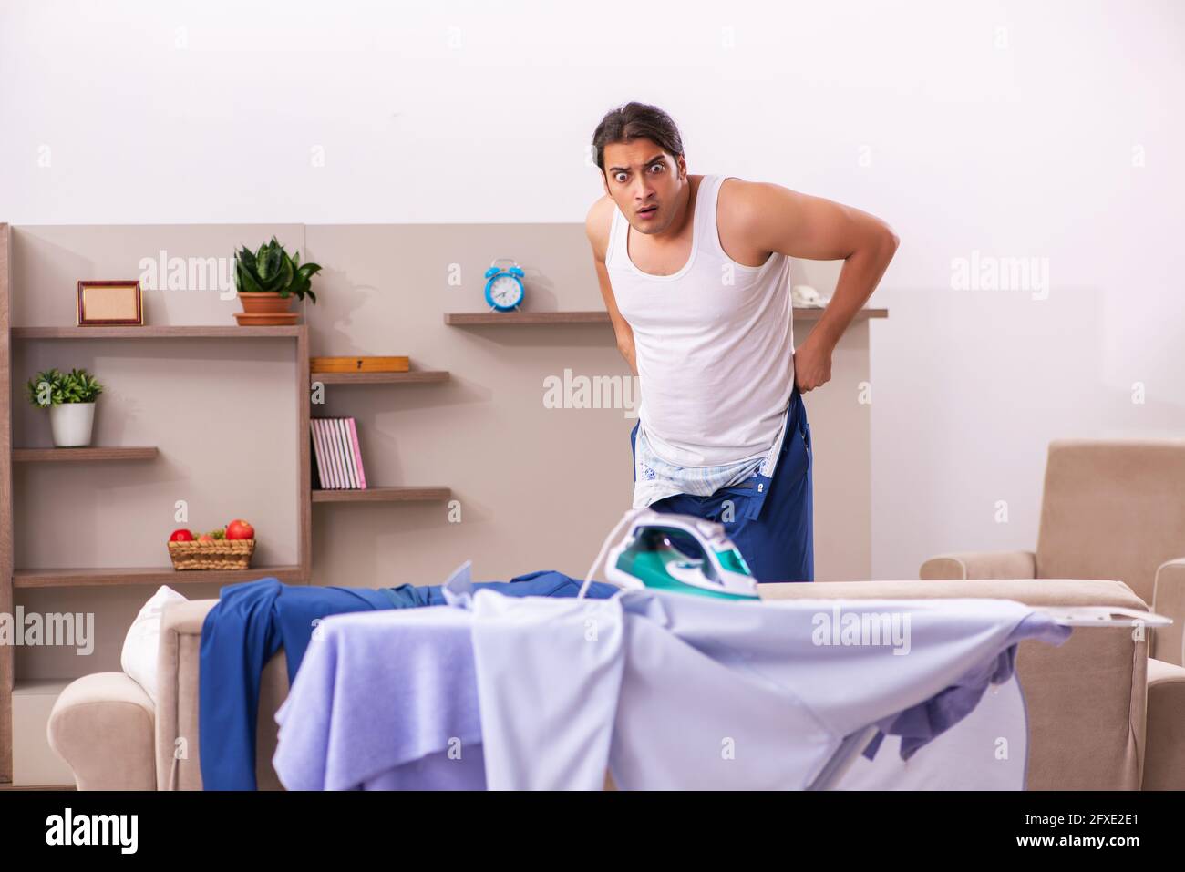 Young employee ironing in the morning Stock Photo - Alamy