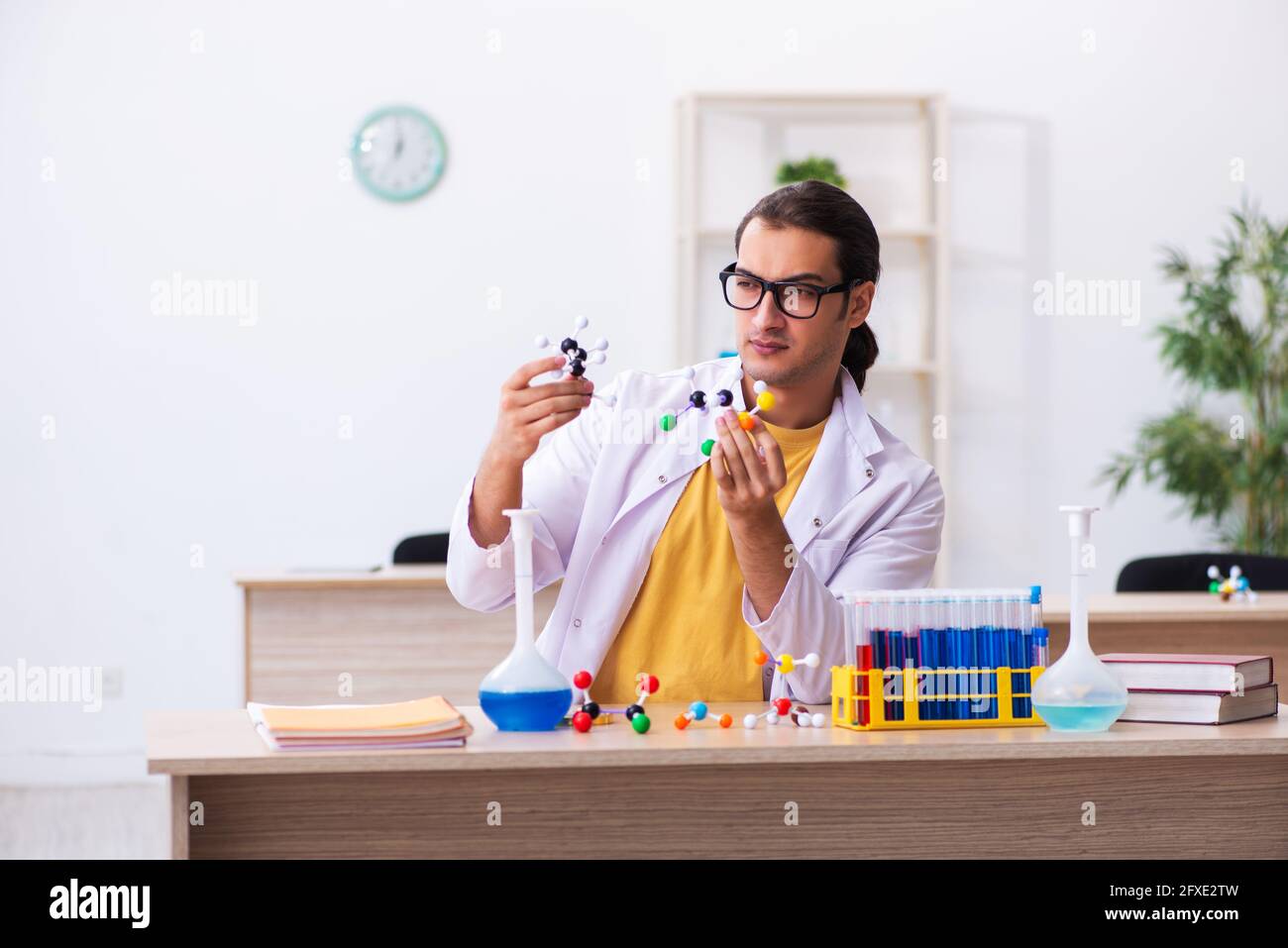 Young chemist studying molecular model in the classroom Stock Photo - Alamy