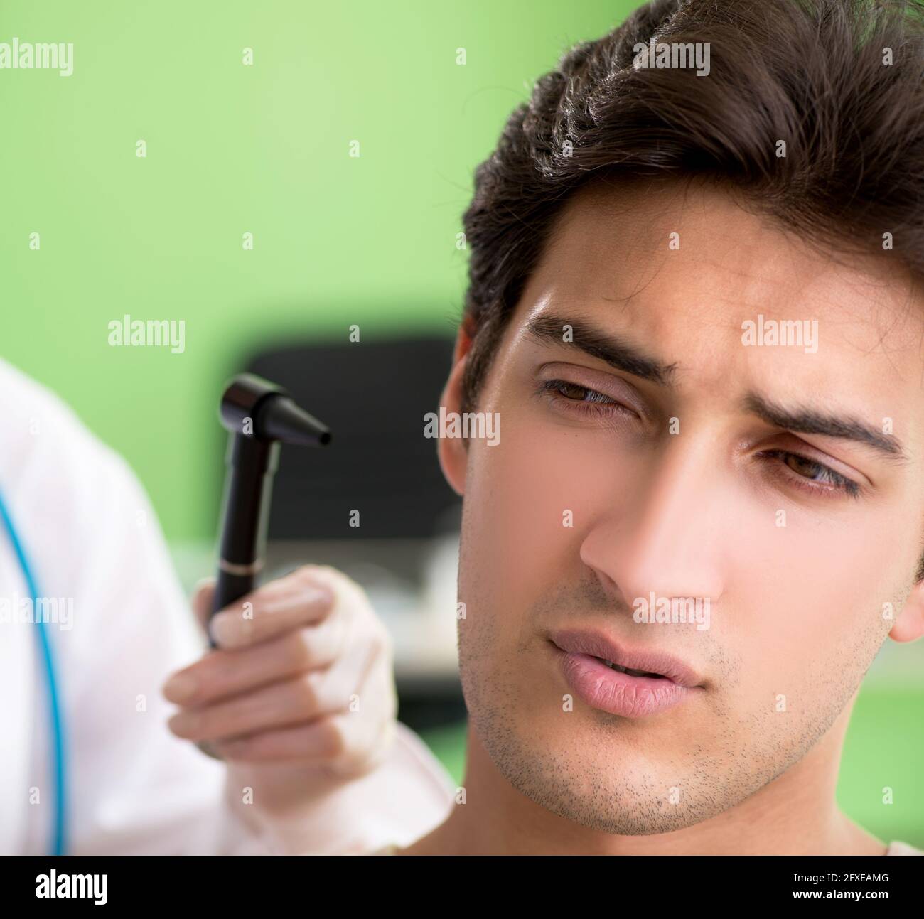 The female doctor checking patient's ear during medical examination ...