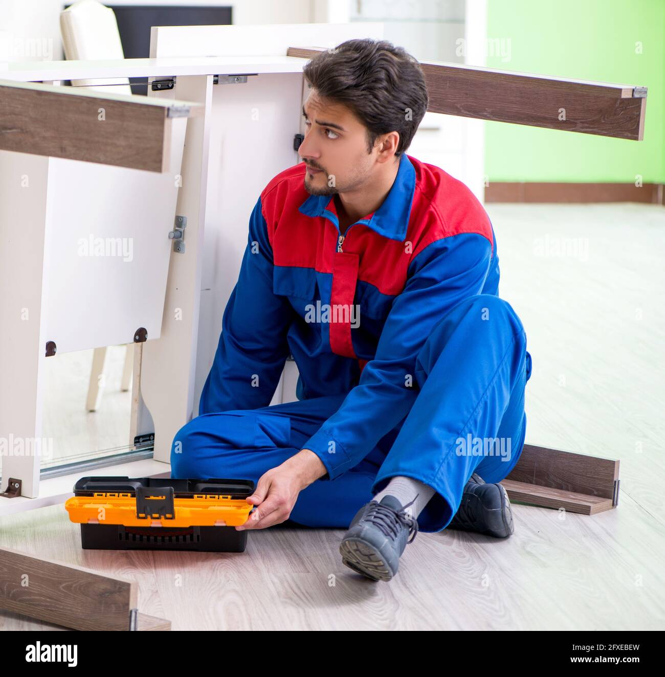 The repair contractor repairing broken furniture at home Stock Photo ...