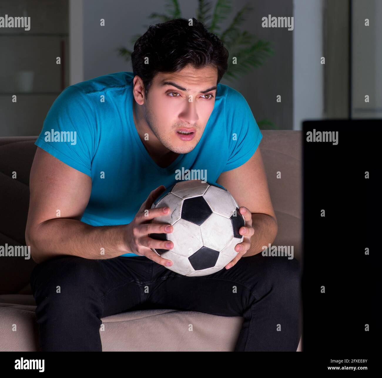 The young man watching football late at night Stock Photo - Alamy