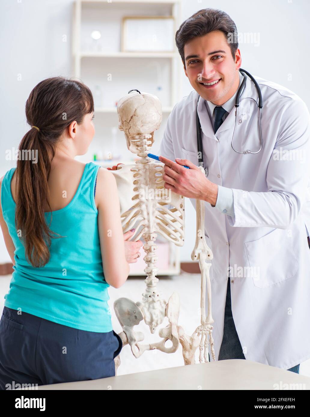 The doctor showing type of injury on skeleton to patient Stock Photo ...