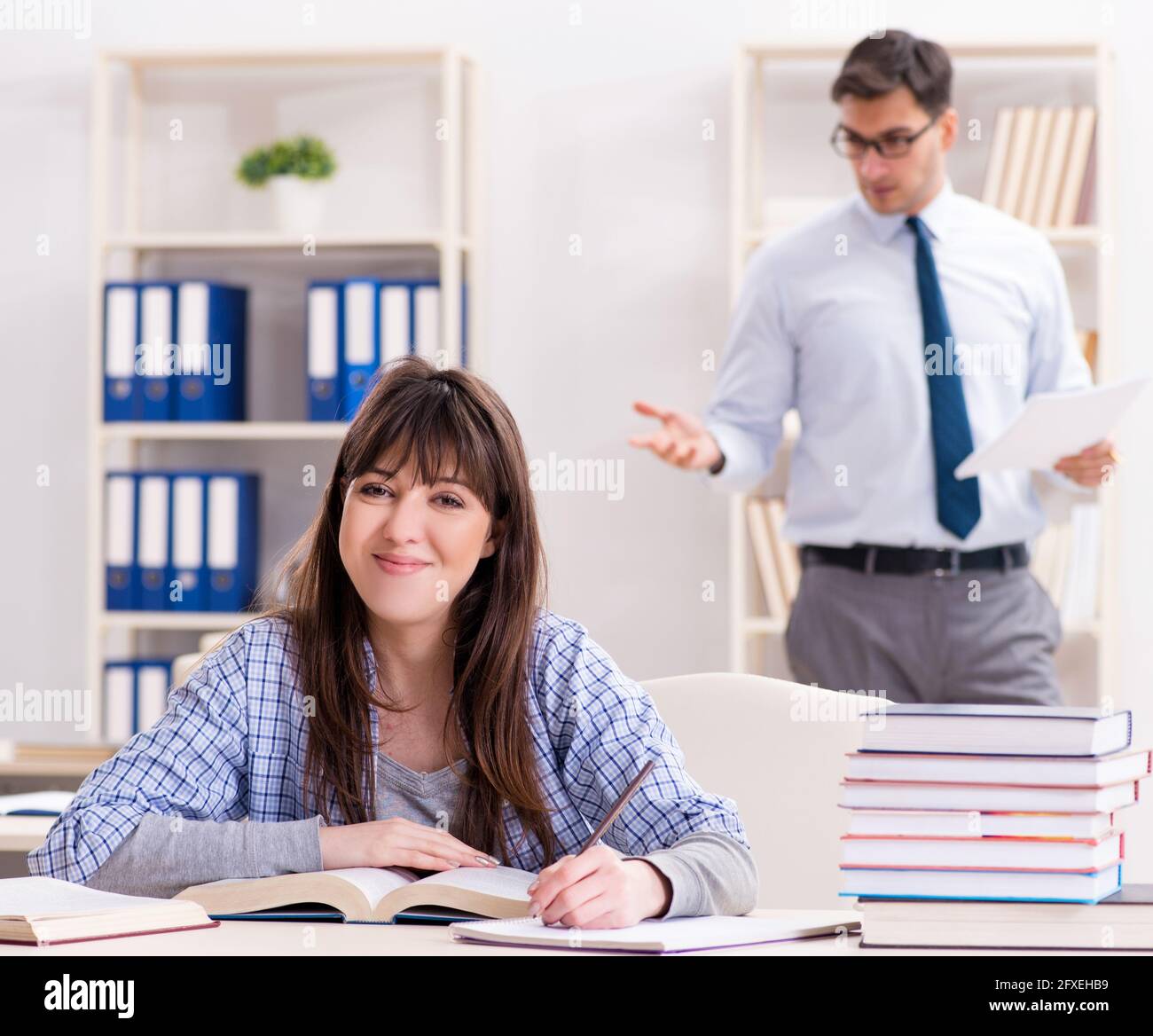 The male lecturer giving lecture to female student Stock Photo - Alamy
