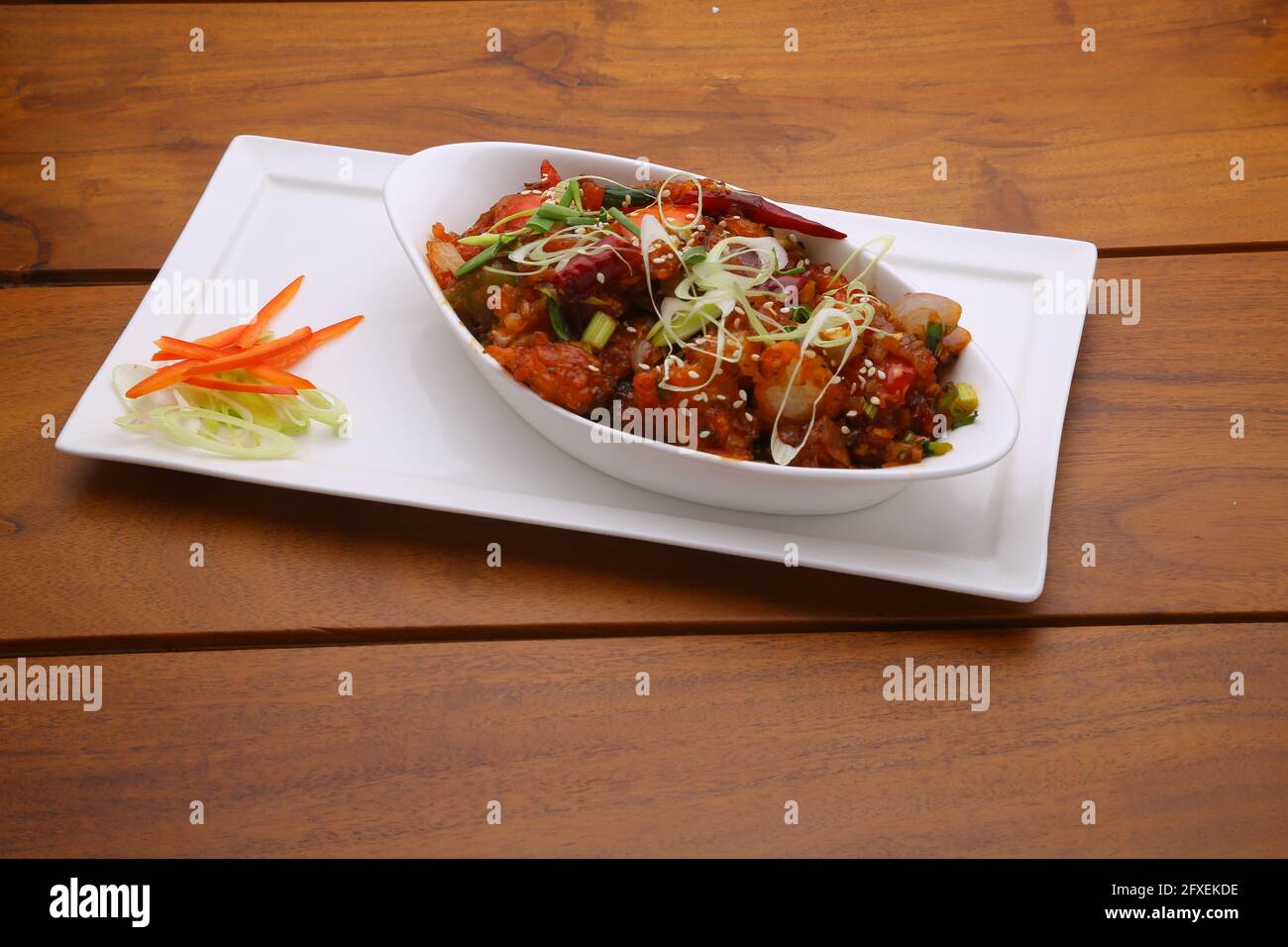 Chilli Chicken dry,well garnished and arranged in an oval shaped bowl ...