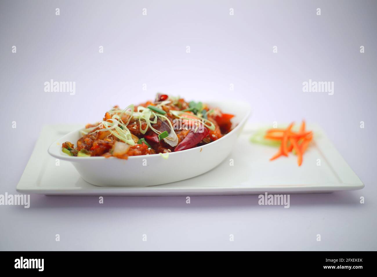 Chilli Chicken dry,well garnished and arranged in an oval shaped bowl ...