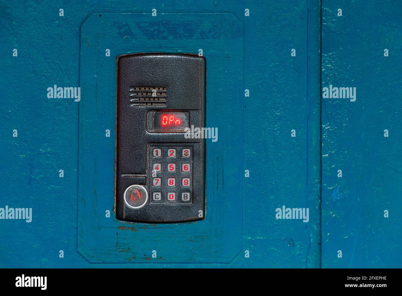 An intercom on old painted classic blue steel surface with a keypad ...