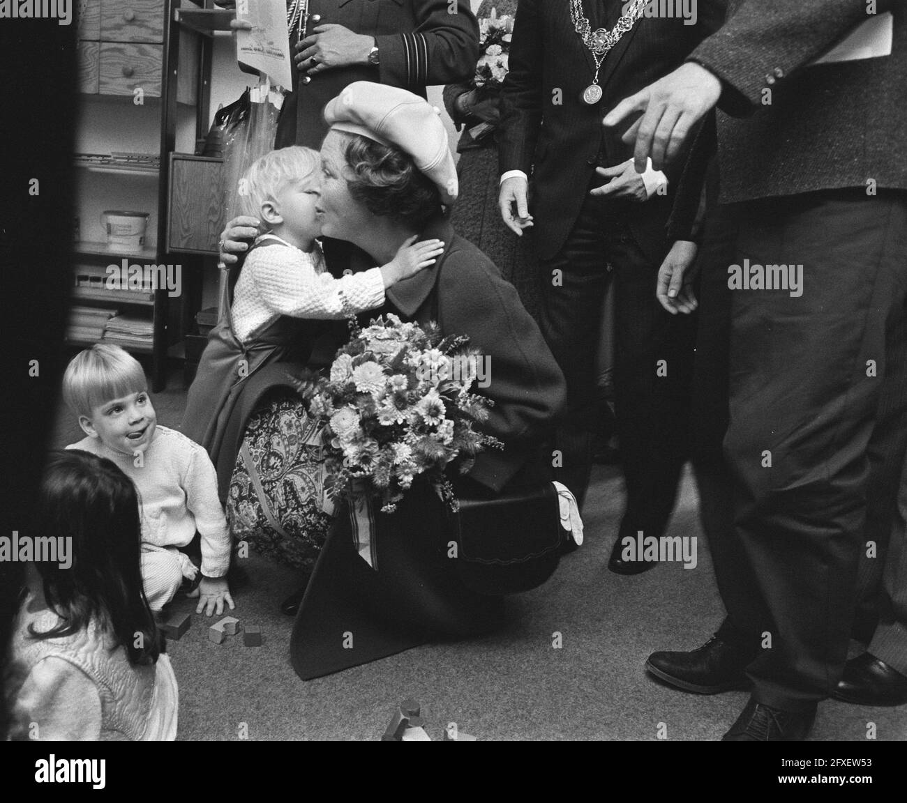 Queen Beatrix receives a kiss from a child at a daycare center, October ...