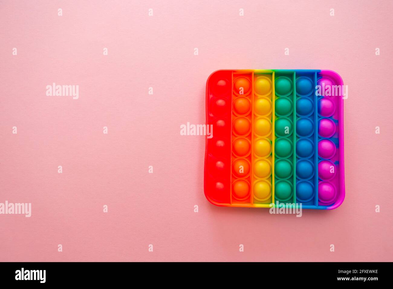 Colorful antistress pop it toy on the pink background Stock Photo - Alamy